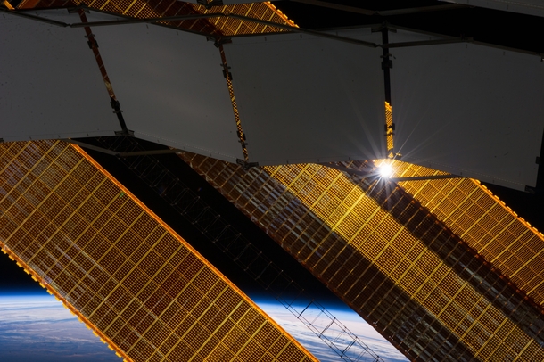 The sun shines through the solar panels of the ISS - Photorator